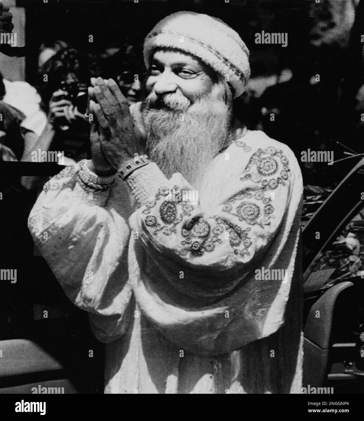 Indian guru Bhagwan Shree Rajneesh greets his followers, or sannyasins ...