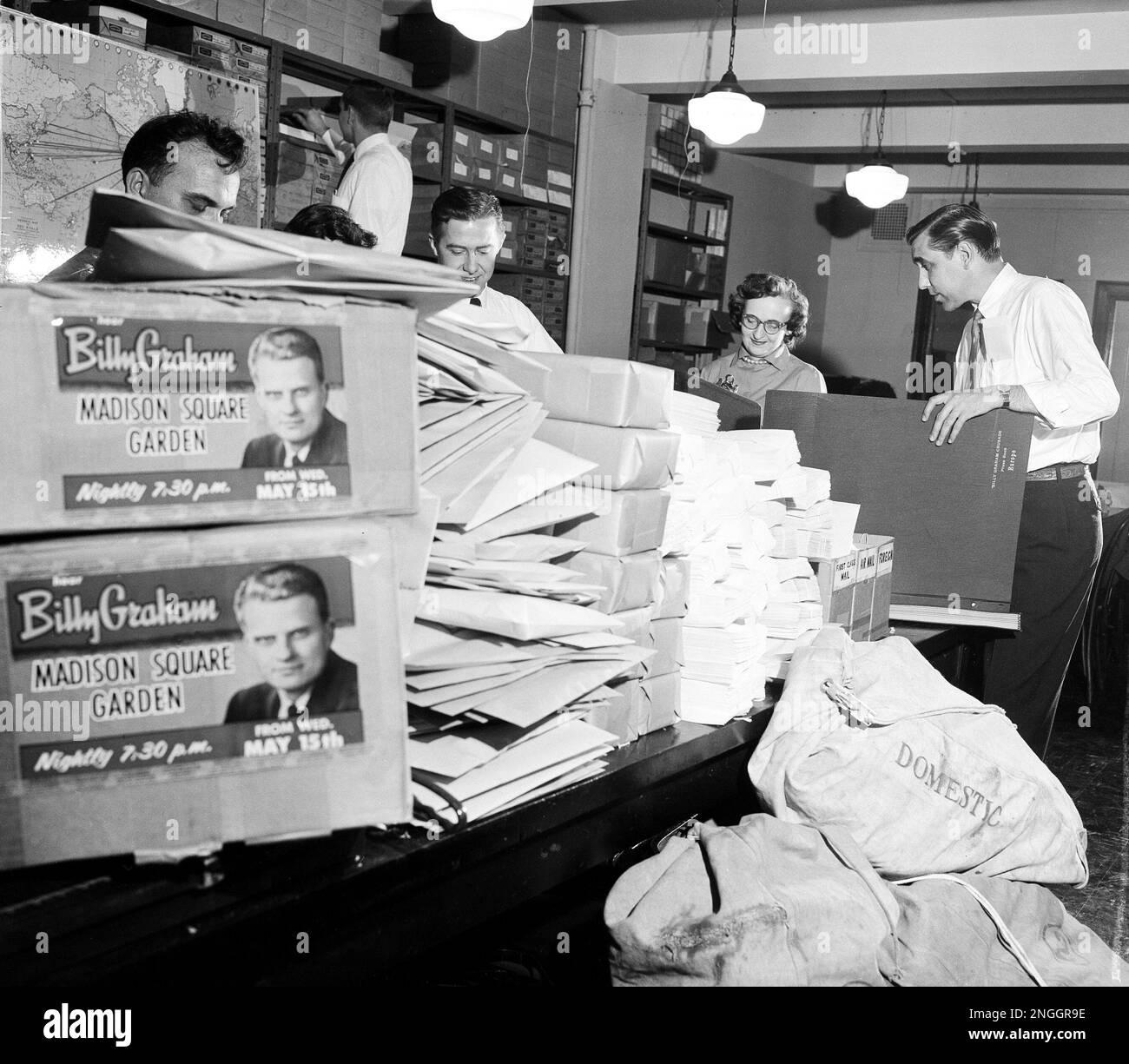Campaign workers, surrounded by stacks of mailing material, get ready ...