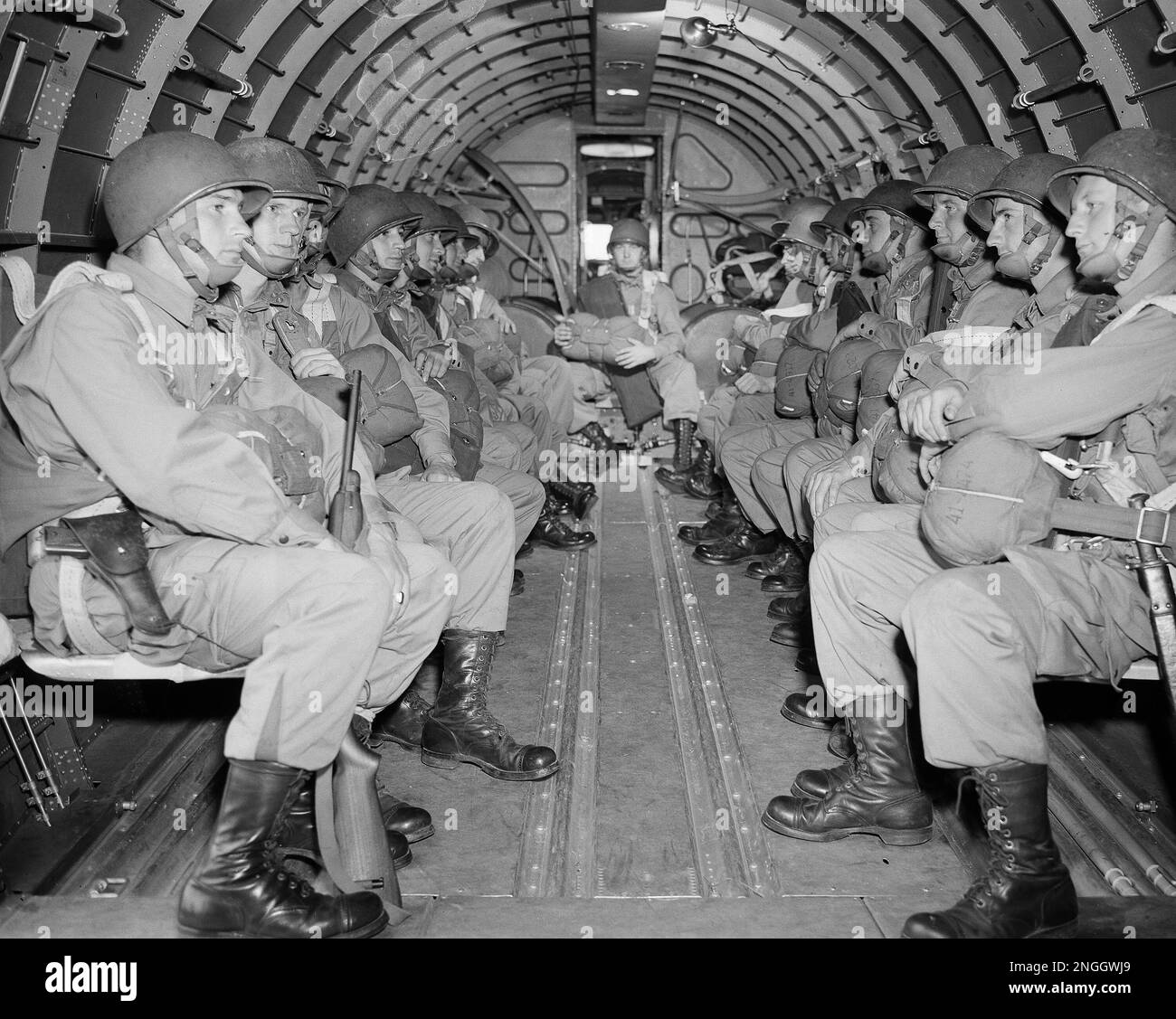 American paratroopers, heavily armed, sit inside a military plane as ...