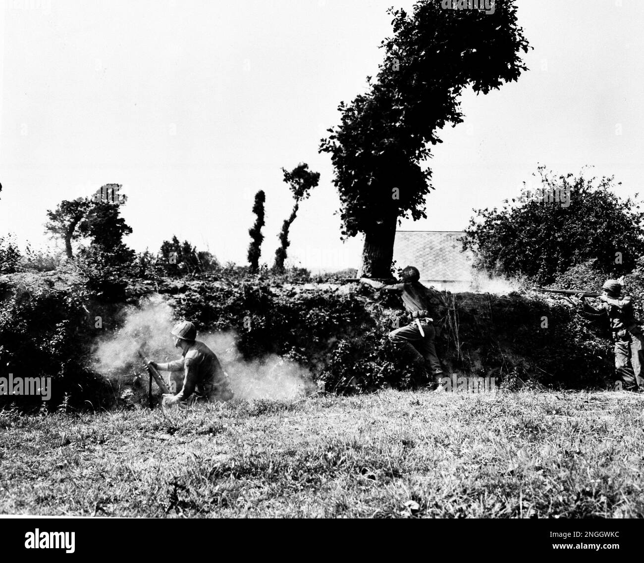 American infantrymen fire from behind hedgerows as they battle the ...