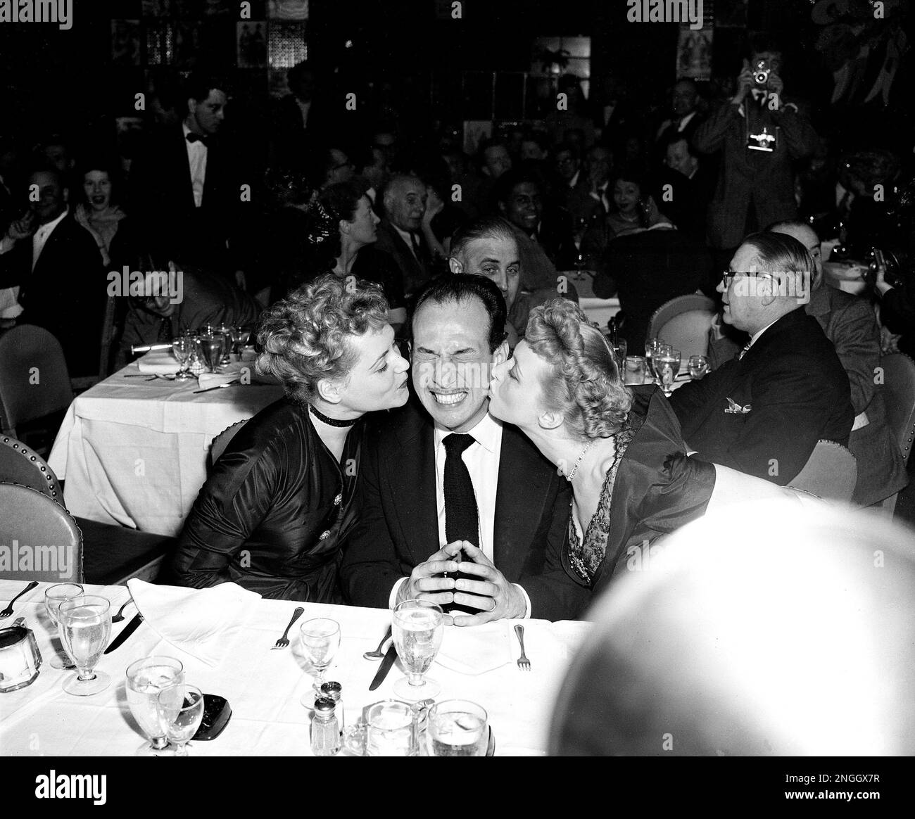 Jose Ferrer is kissed by Judy Holliday, left, and Celeste Holm at a ...