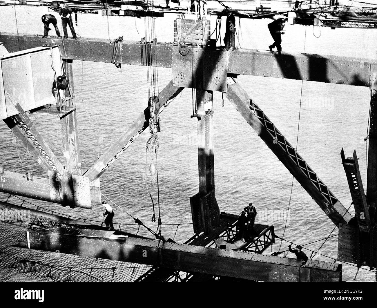 Workmen assist the derrick operator, chief engineer Joseph Strauss, in ...