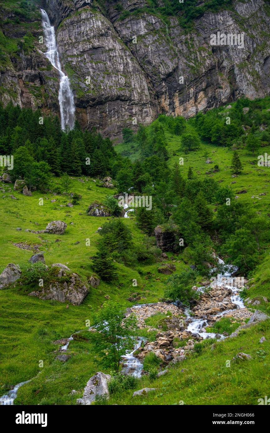 a waterfall that flows down a high cliff and flows into a stream Stock ...