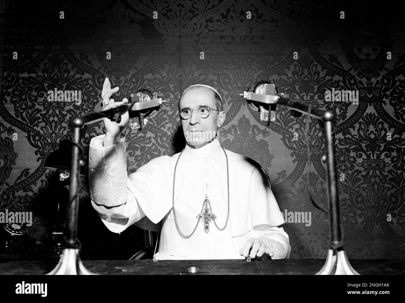 Pope Pius XII appears behind microphones during a radio broadcast from ...