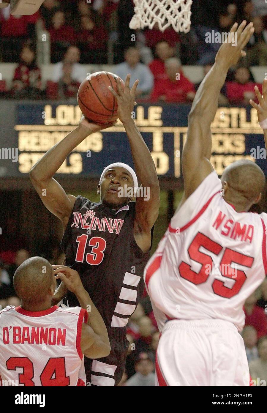 Cincinnati's Leonard Stokes goes up between Louisville players Larry O ...