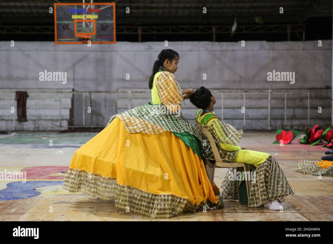 A performer helps her groupmate with her hair hours before the 2023 Sikhayan festival. Locals ...