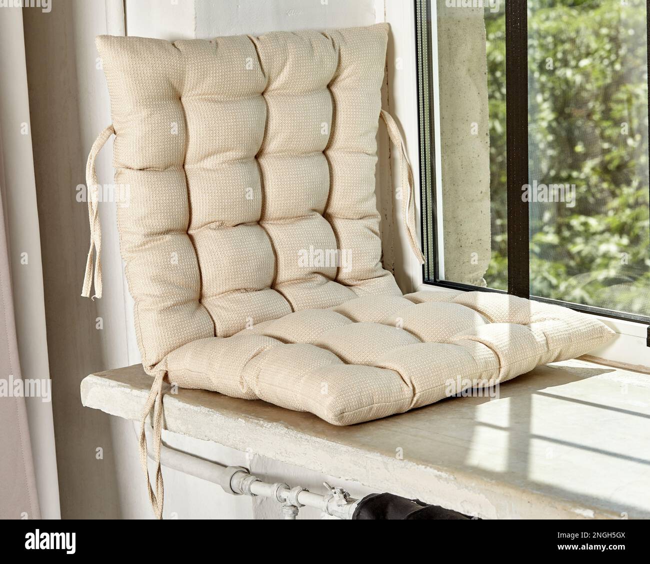 Warm and cozy window seat with soft beige fabric cushion in sunbeams ...