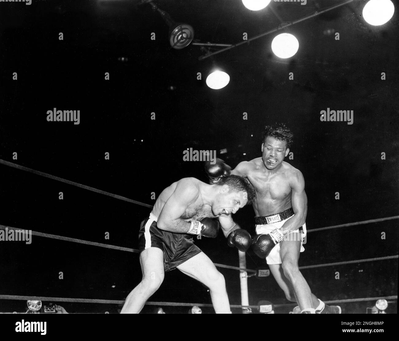 Challenger Sugar Ray Robinson, his lip bleeding, grazes a right toss on ...