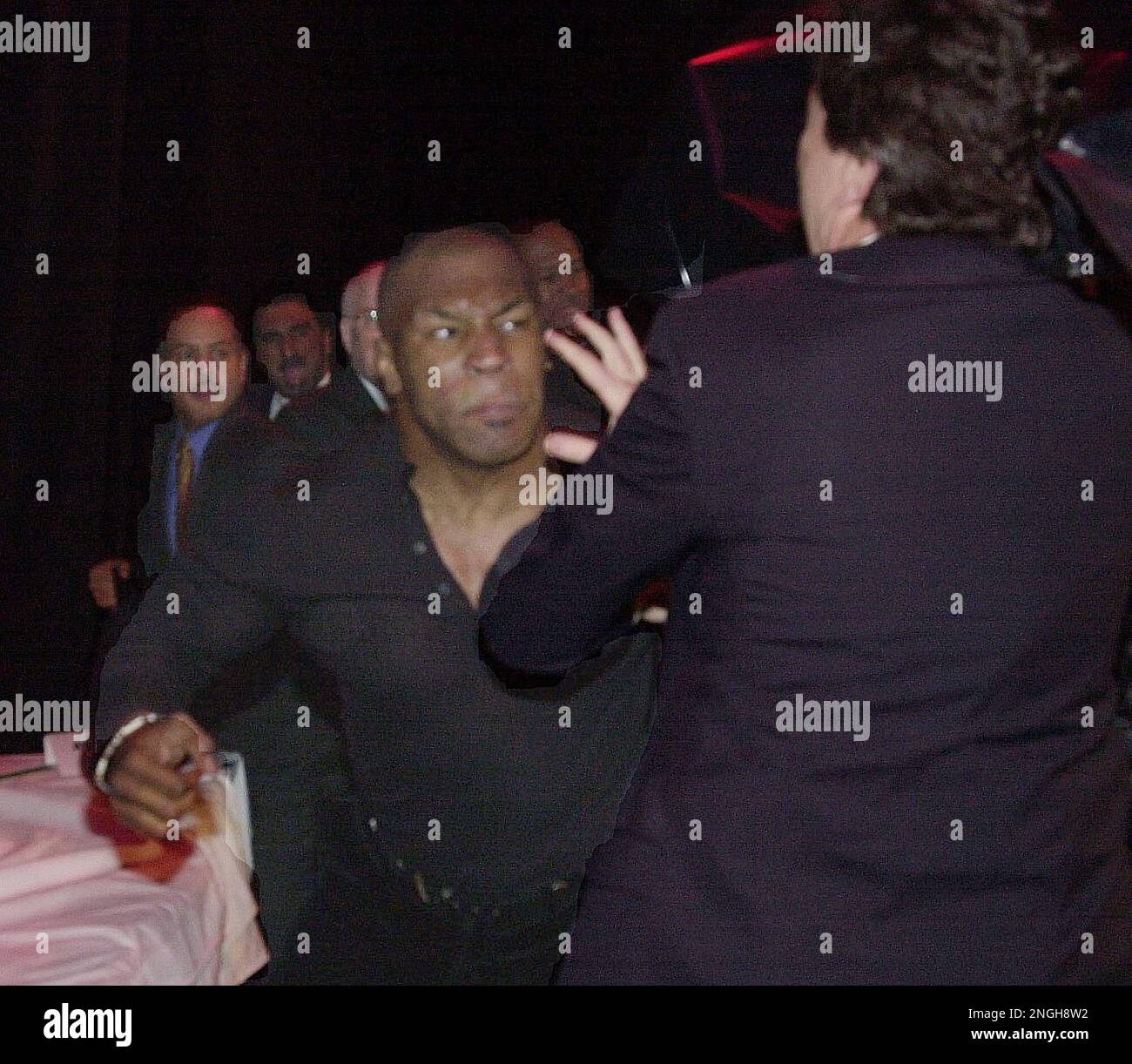 Heavyweight boxer Mike Tyson, center, punches a bodyguard, right, after ...