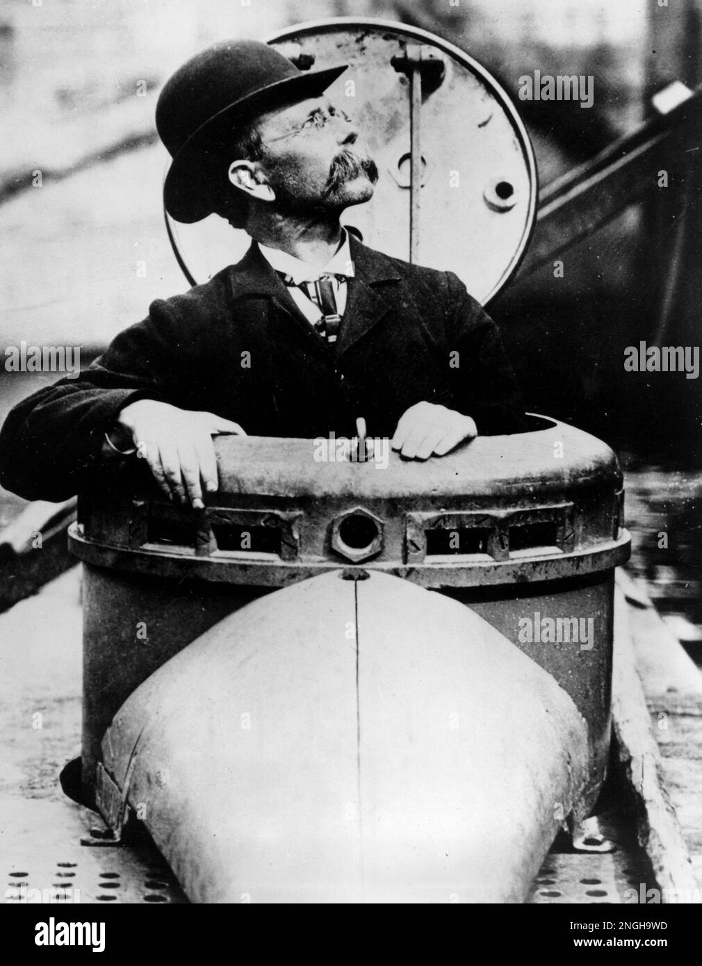 American inventor John P. Holland climbs from a hatch on his submarine ...