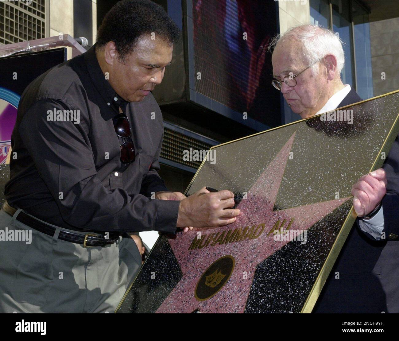 Boxing legend Muhammad Ali, left, signs a replica of his star for the ...