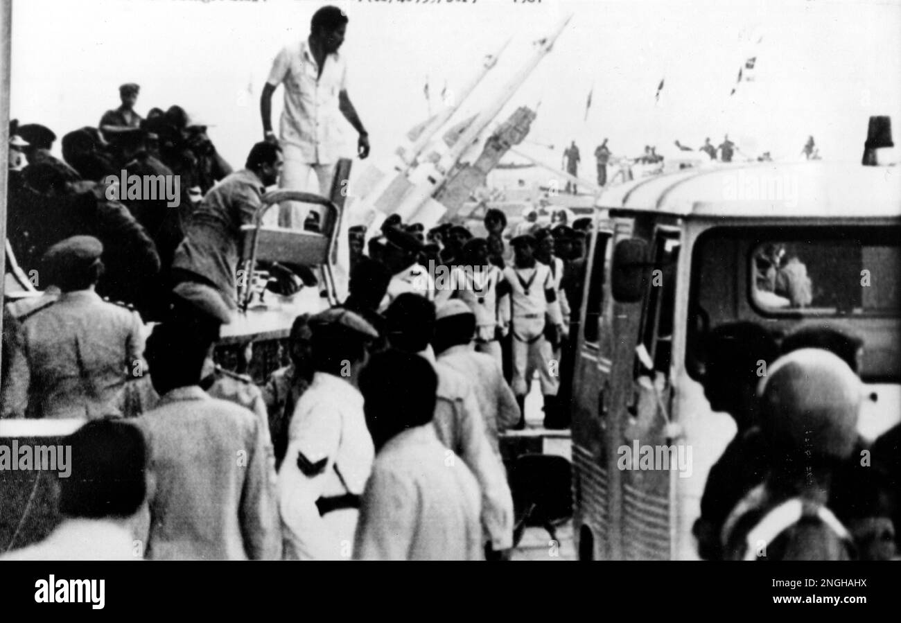 An Egyptian security guard stands on retaining wall in front of a ...