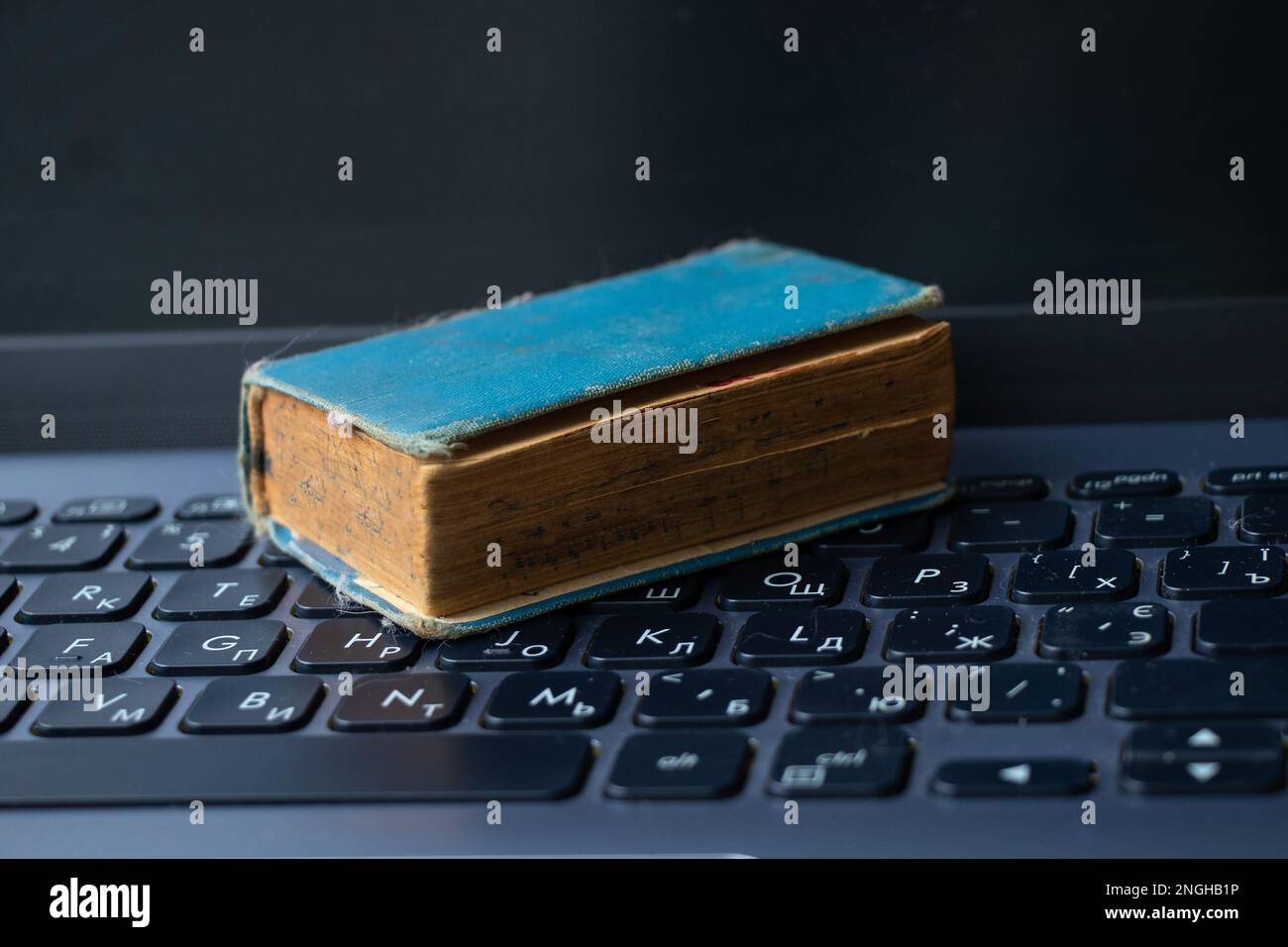 little old book lies on a laptop keyboard Stock Photo - Alamy