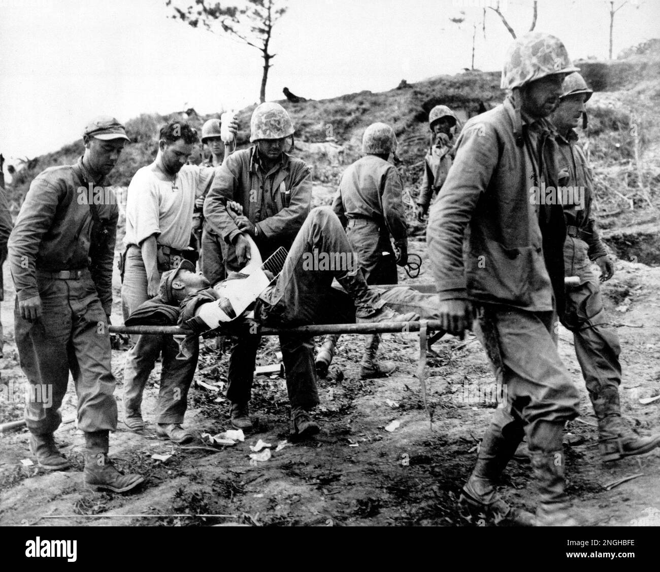A U.S. Navy corpsman administers blood plasma to a wounded Marine as he ...