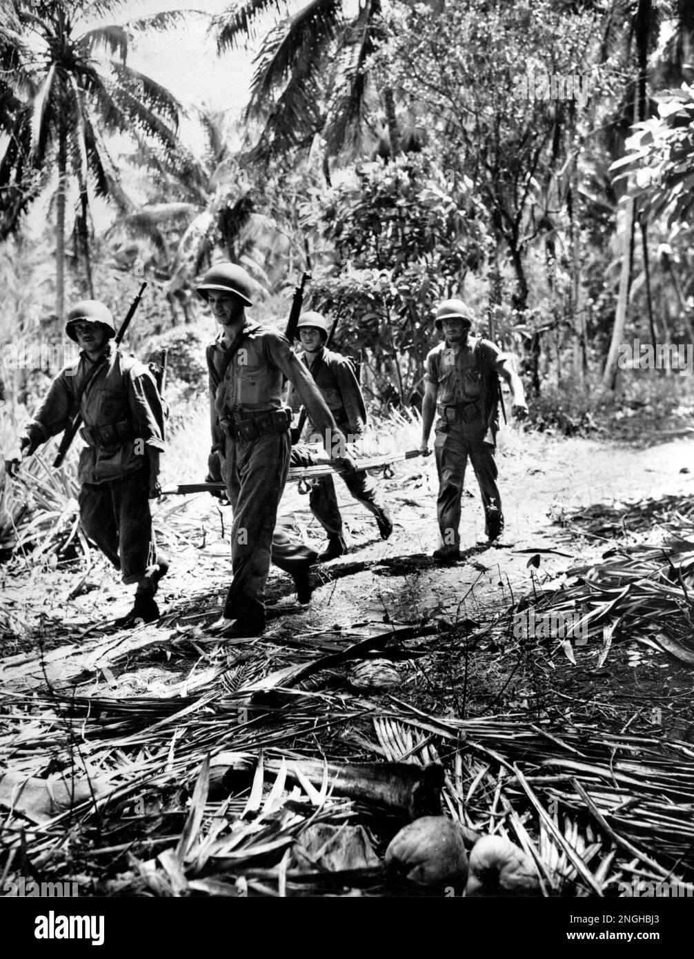 U.S. Marines carry a wounded soldier on a stretcher thorugh the jungle ...