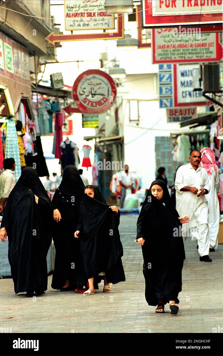 Two Saudi women wear the black abaya and veil called the burka, worn by ...