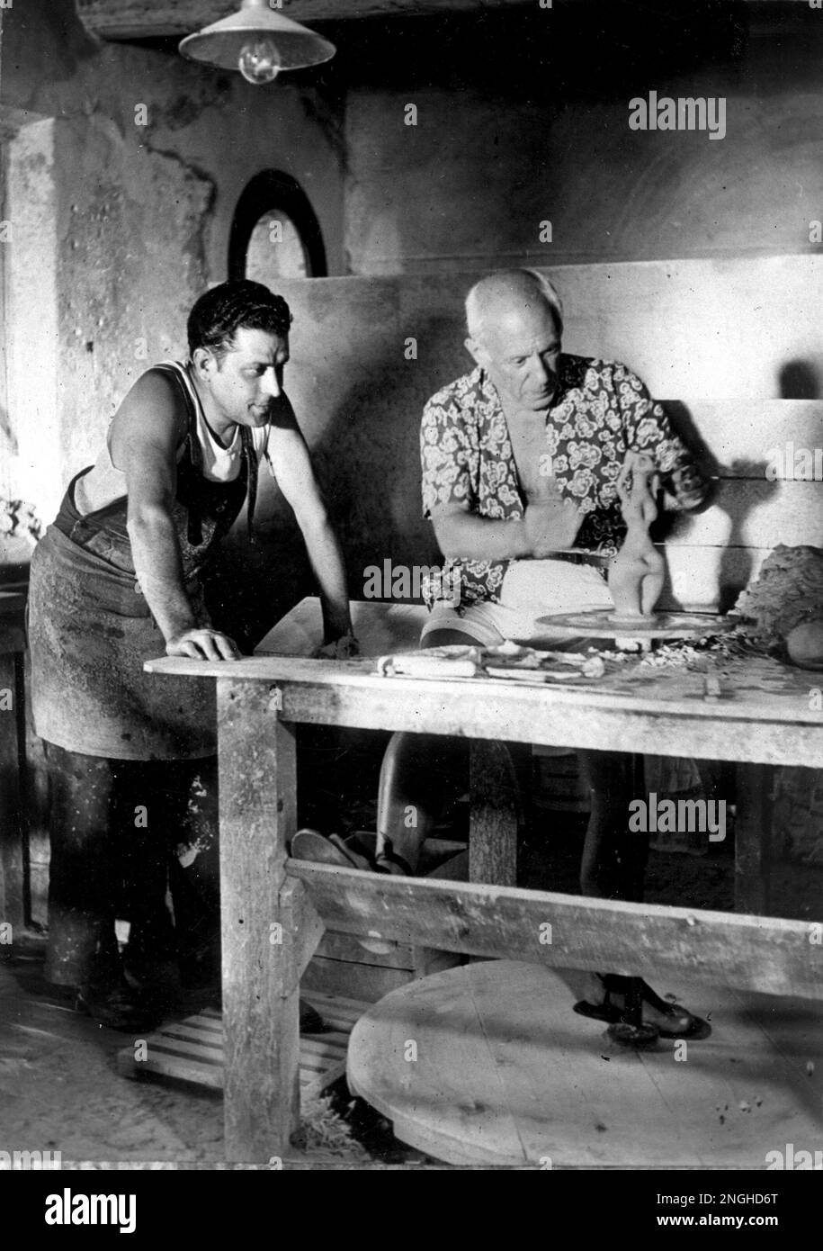 Pablo Picasso models a clay statue using a foot powered potter's wheel ...