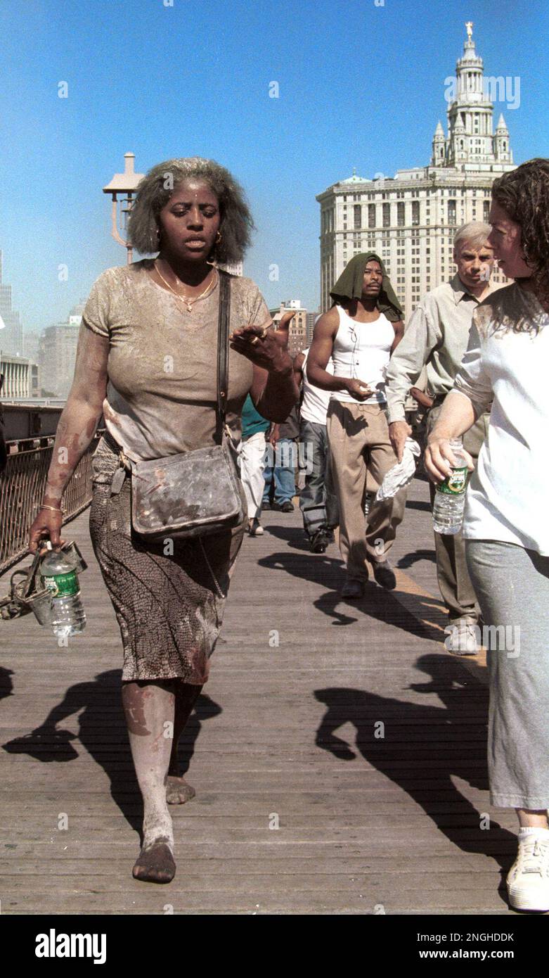 An injured women and others flee lower Manhattan across the Brooklyn ...