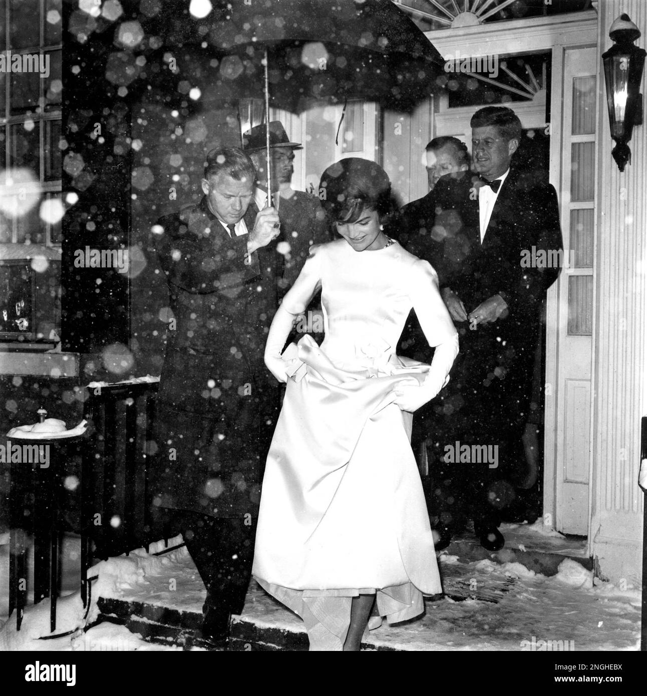 Jacqueline Kennedy lifts the skirt of her inaugural ball gown as she ...