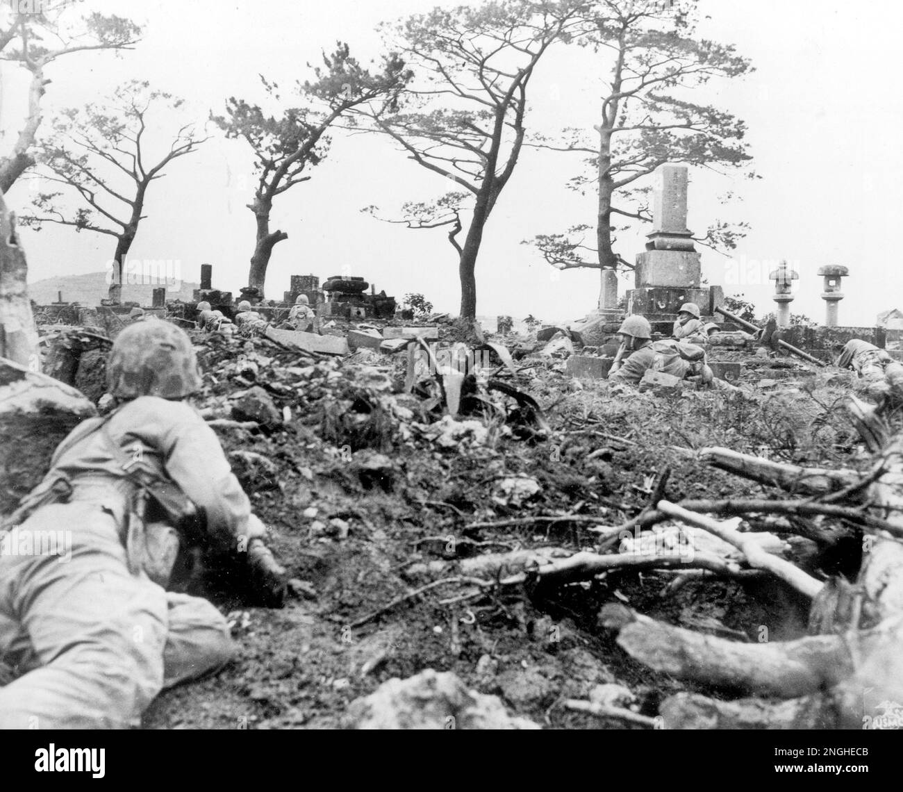 U.S. Marines take cover behind tattered tombstones during their advance ...