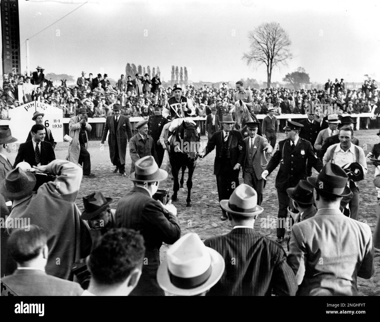 Seabiscuit, with jockey George Woolf up, is led by trainer Tom Smith ...