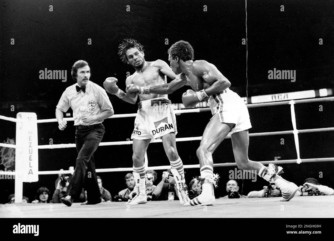 Roberto Duran, left, takes a punch from Sugar Ray Leonard, right ...