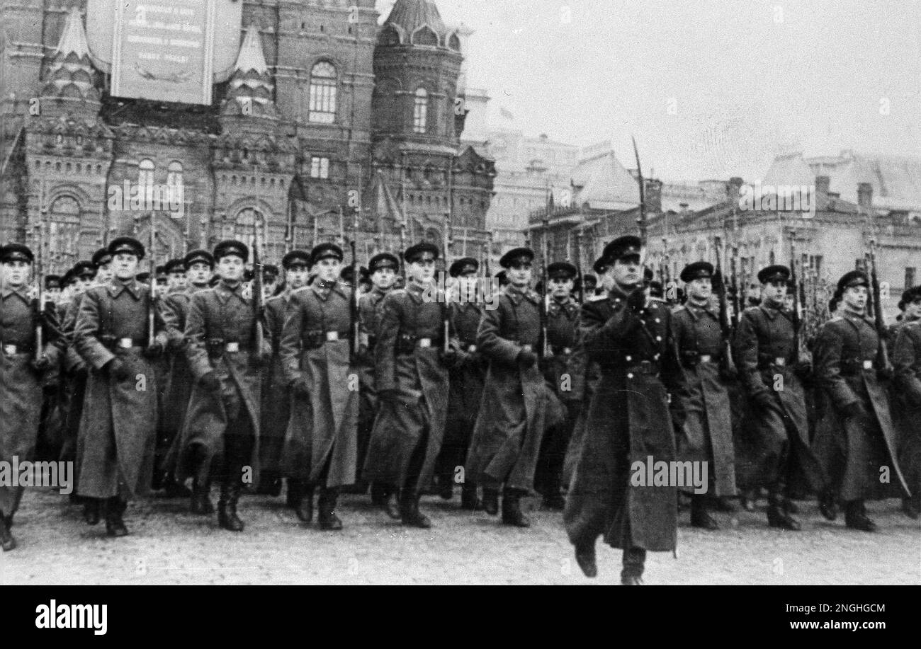 Soviet soldiers are led by a saber saluting officer in a parade through ...