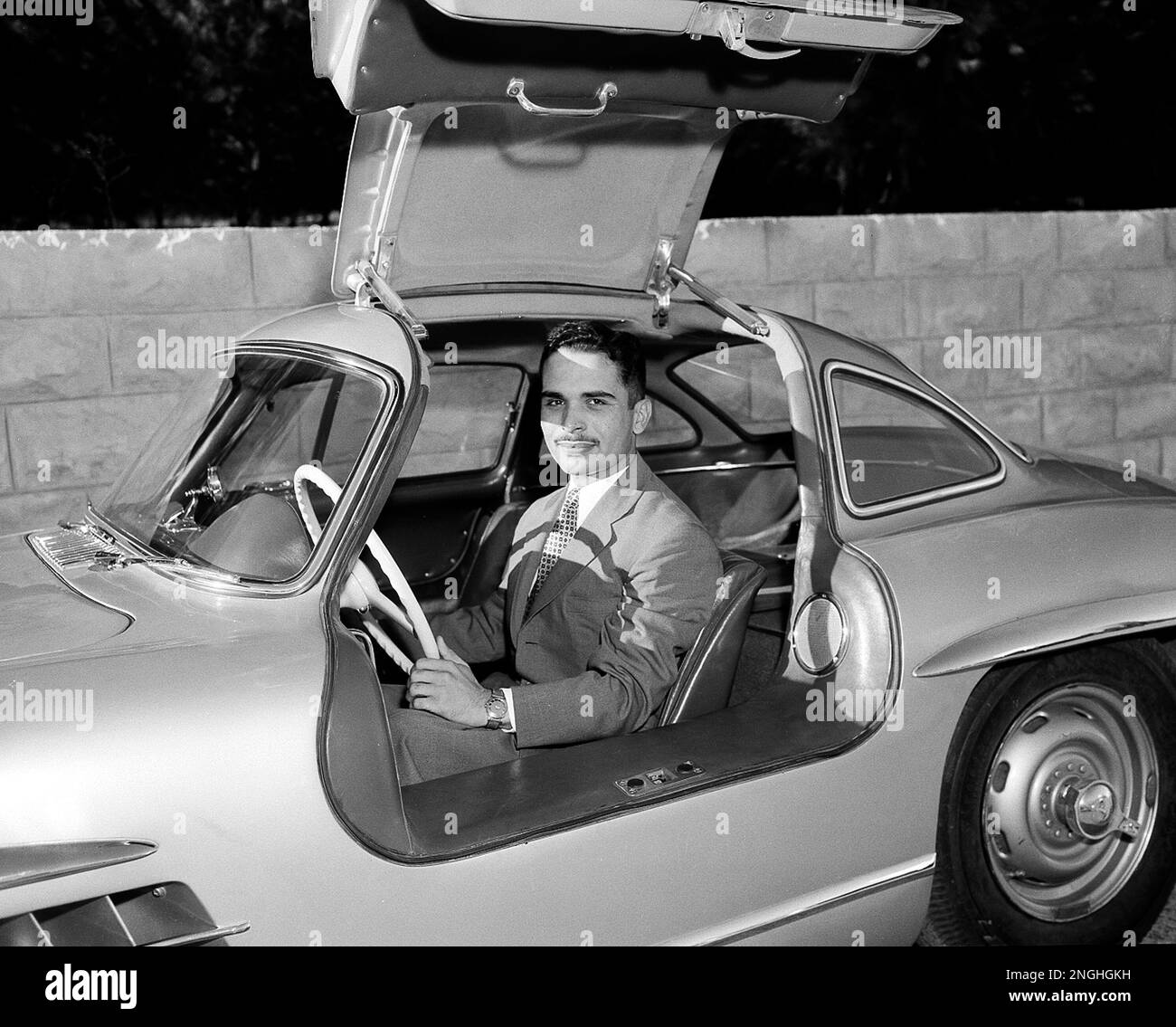King Hussein of Jordan sits in his new Mercedes-Benz sports car at the ...