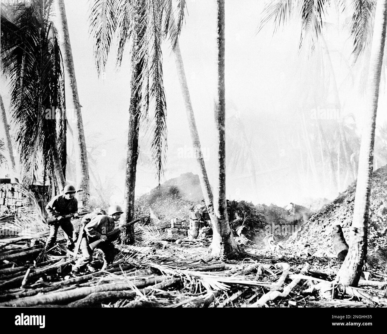 American infantrymen pass a blazing Japanese ammunition dump in the ...
