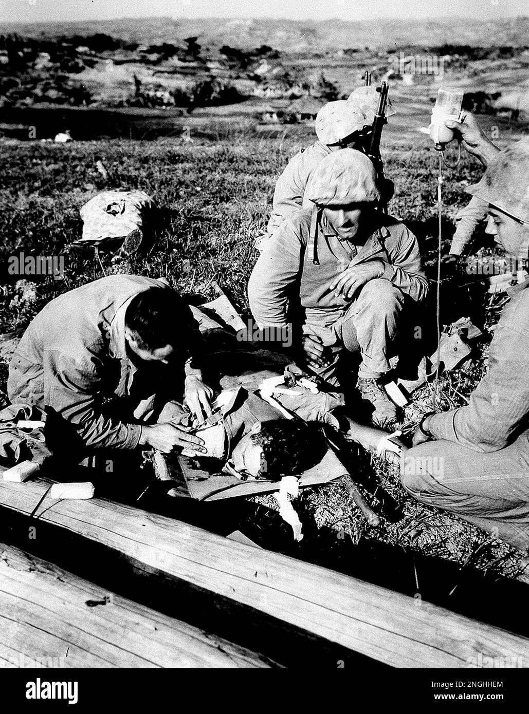 Medical corpsmen administers blood plasma to a wounded U.S. Marine on the battlefield ...