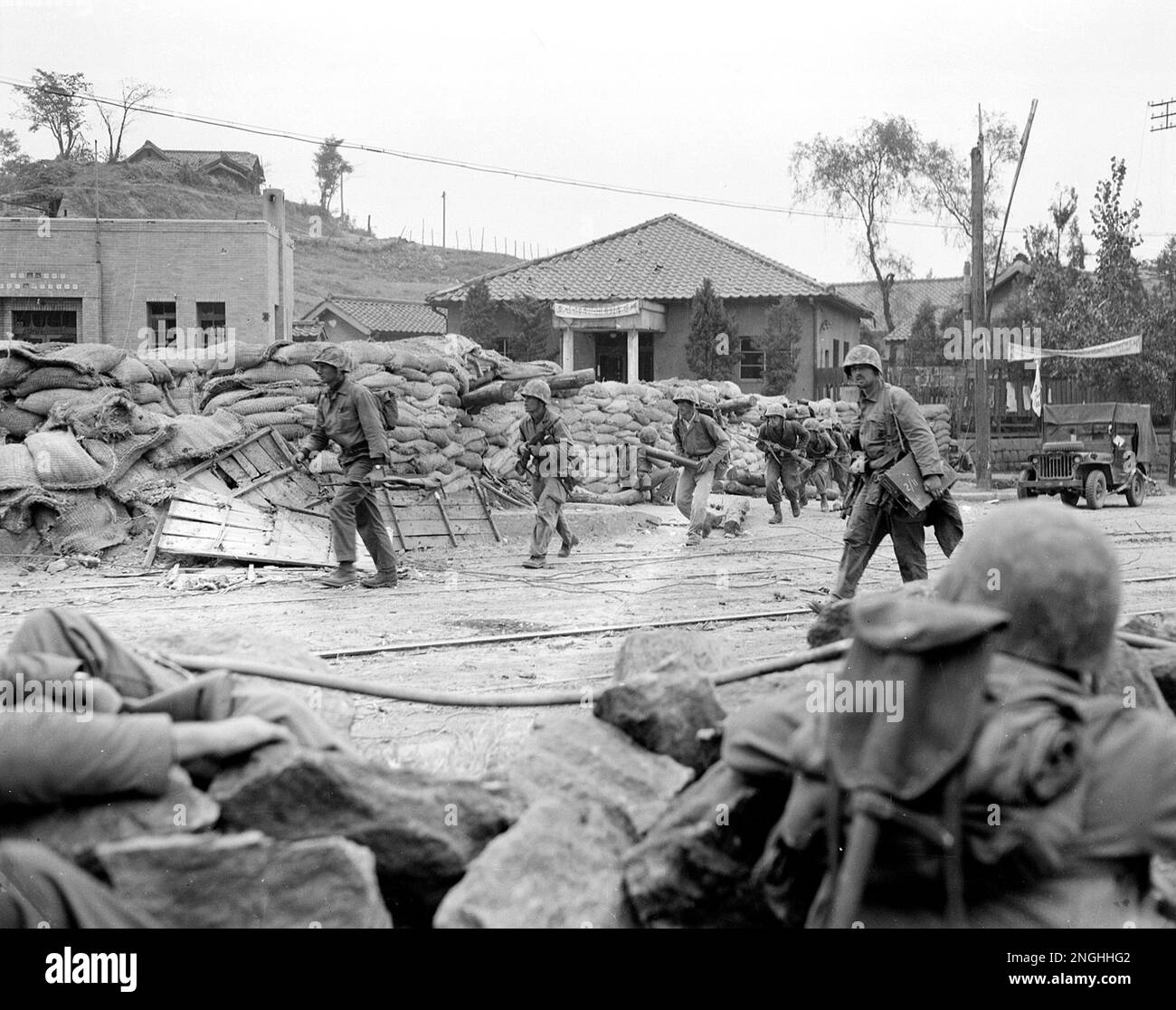 U.S. First Battalion troops move through a road block in Seoul when ...