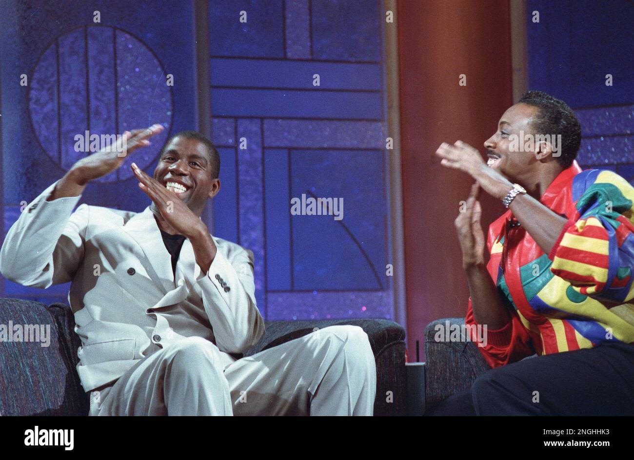 Earvin "Magic" Johnson, left, and host Arsenio Hall gesture for time ...