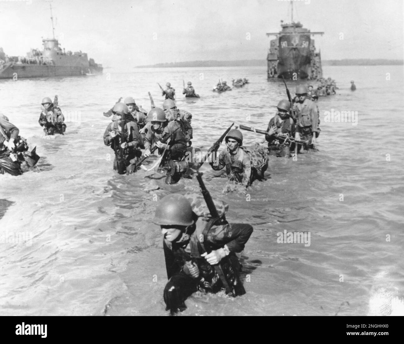 Carrying rifles and equipment, American troops wade ashore through ...