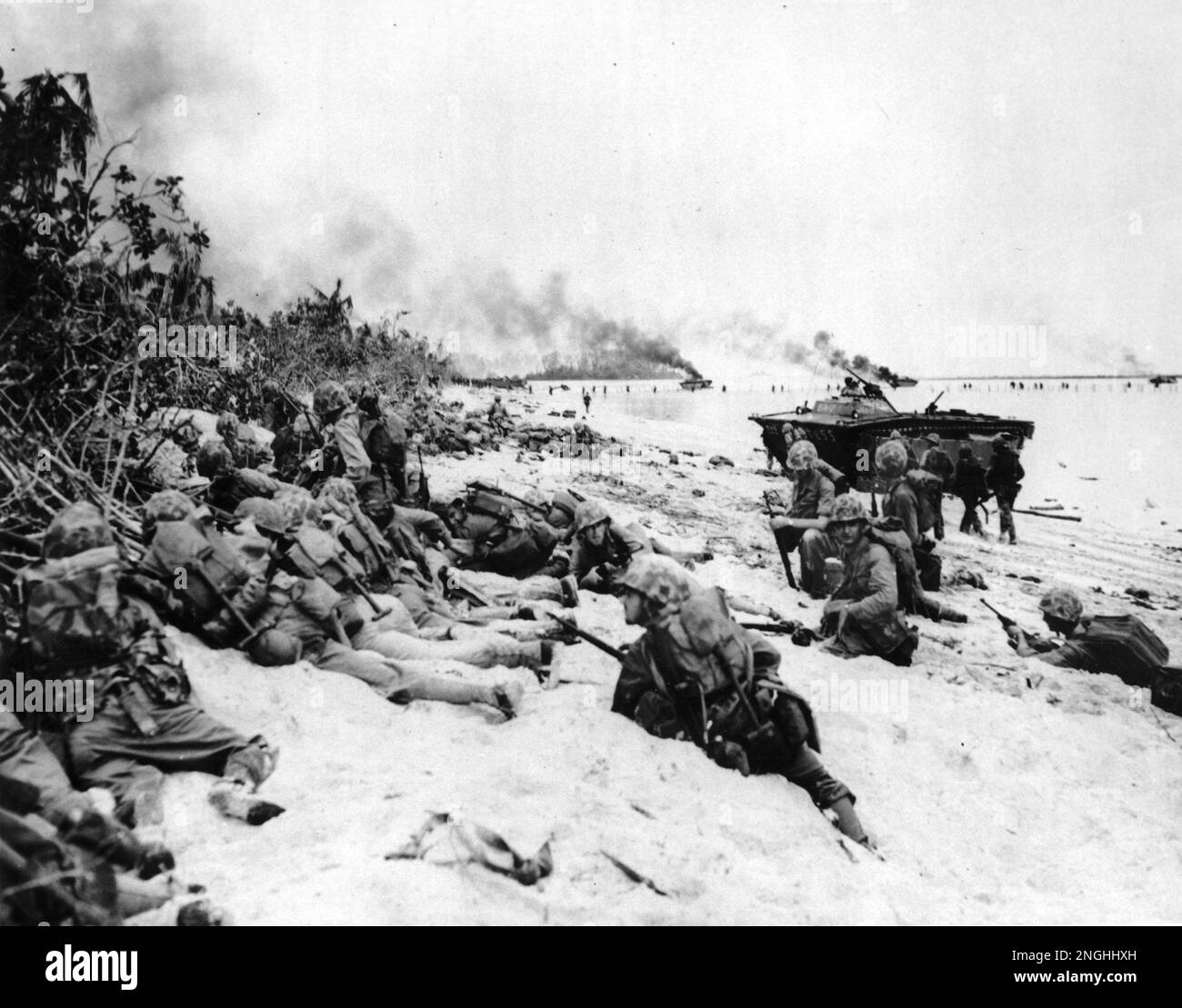 U.S. Marines take advantage of the natural cover on the beach of ...
