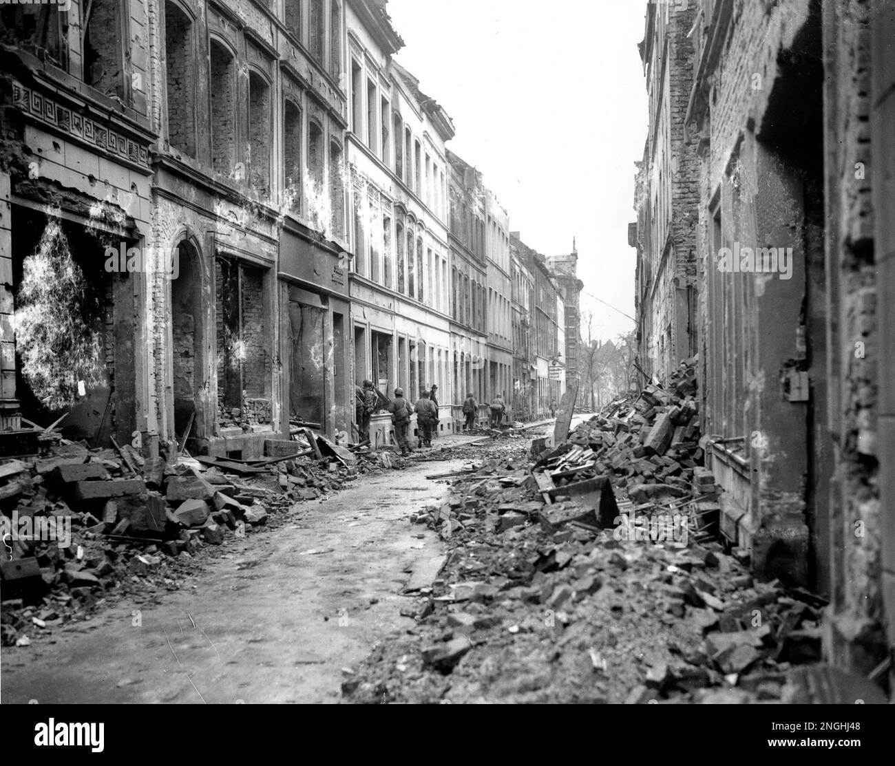 American GI's move cautiously down a street on the look-out for a ...