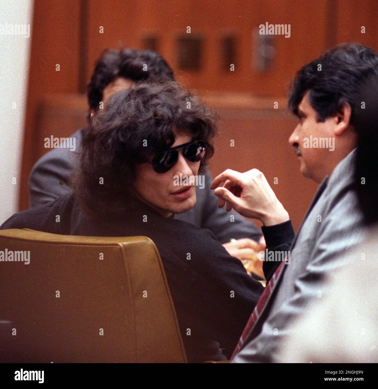 Richard Ramirez, wearing sunglasses, looks over his shoulder around the ...
