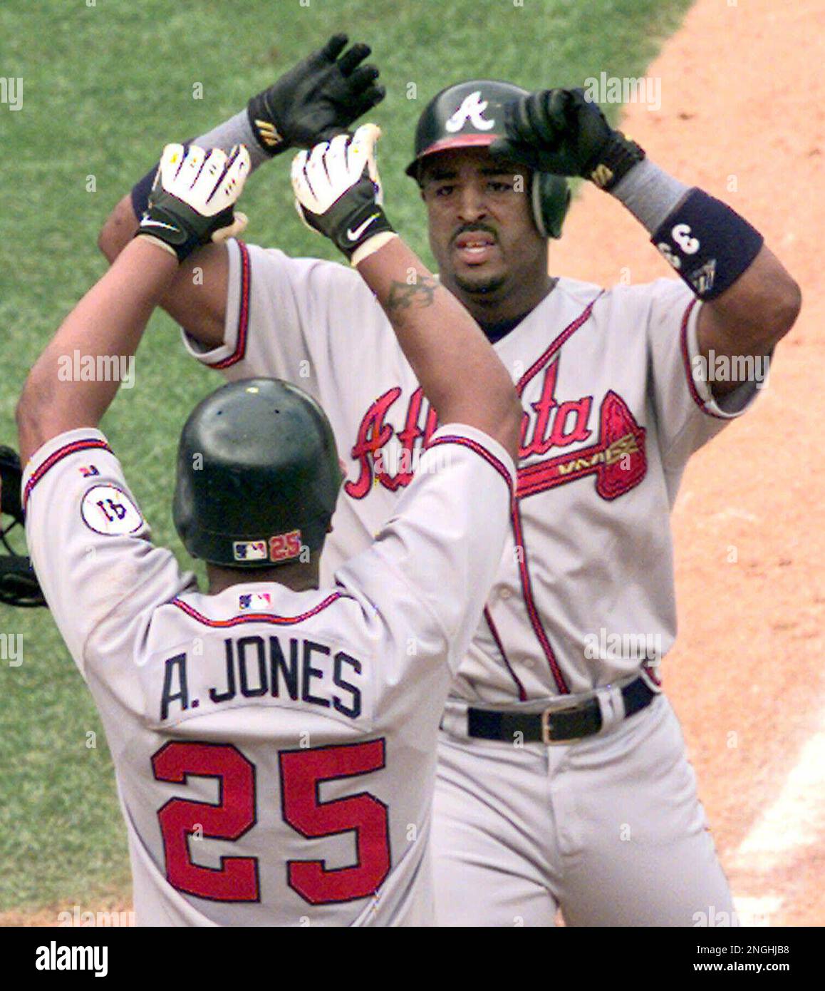 Atlanta Braves' Brian Jordan is greeted at the plate by teammate Andrew ...