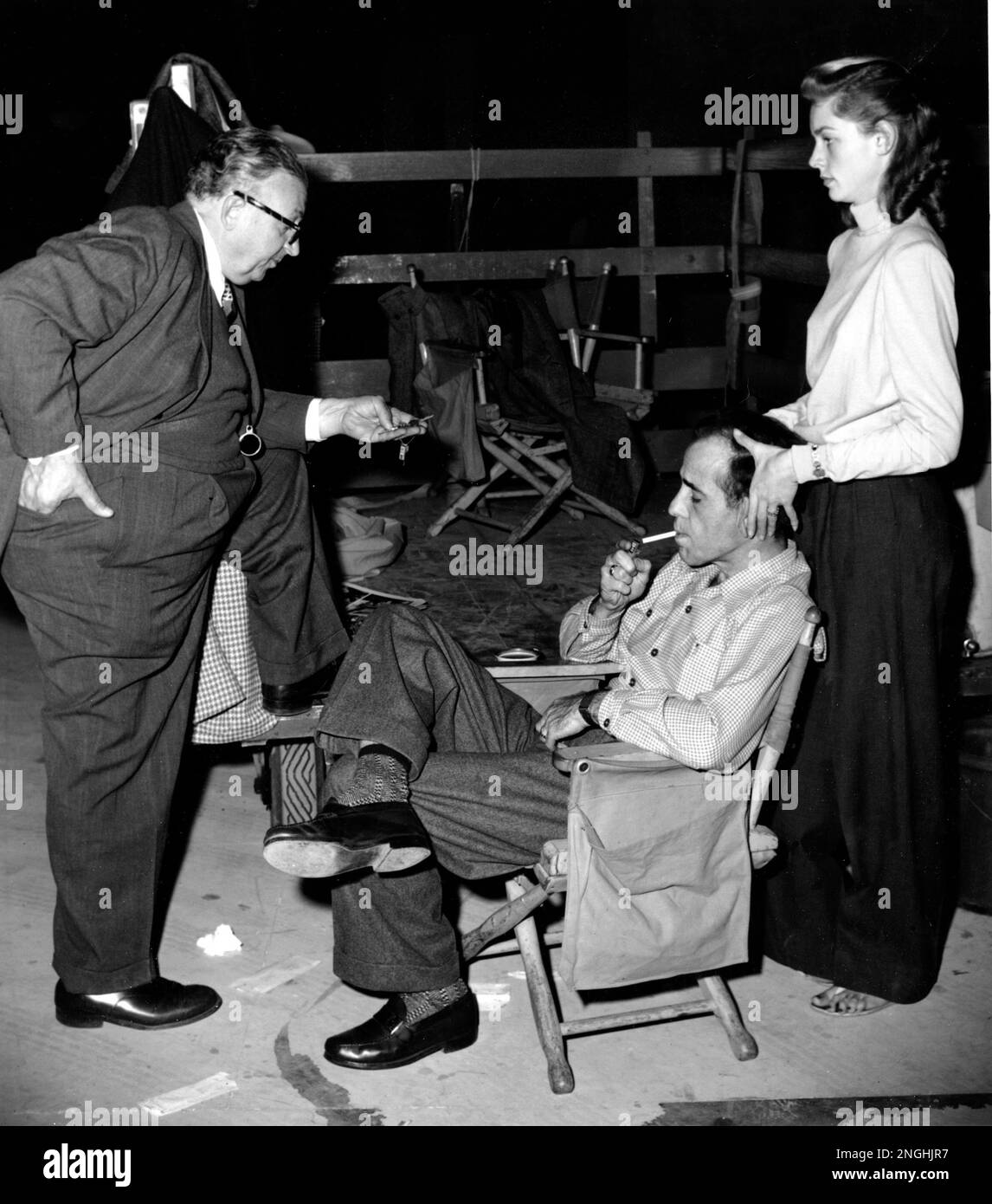 Actor Humphrey Bogart, lighting cigarette, actress Lauren Bacall ...