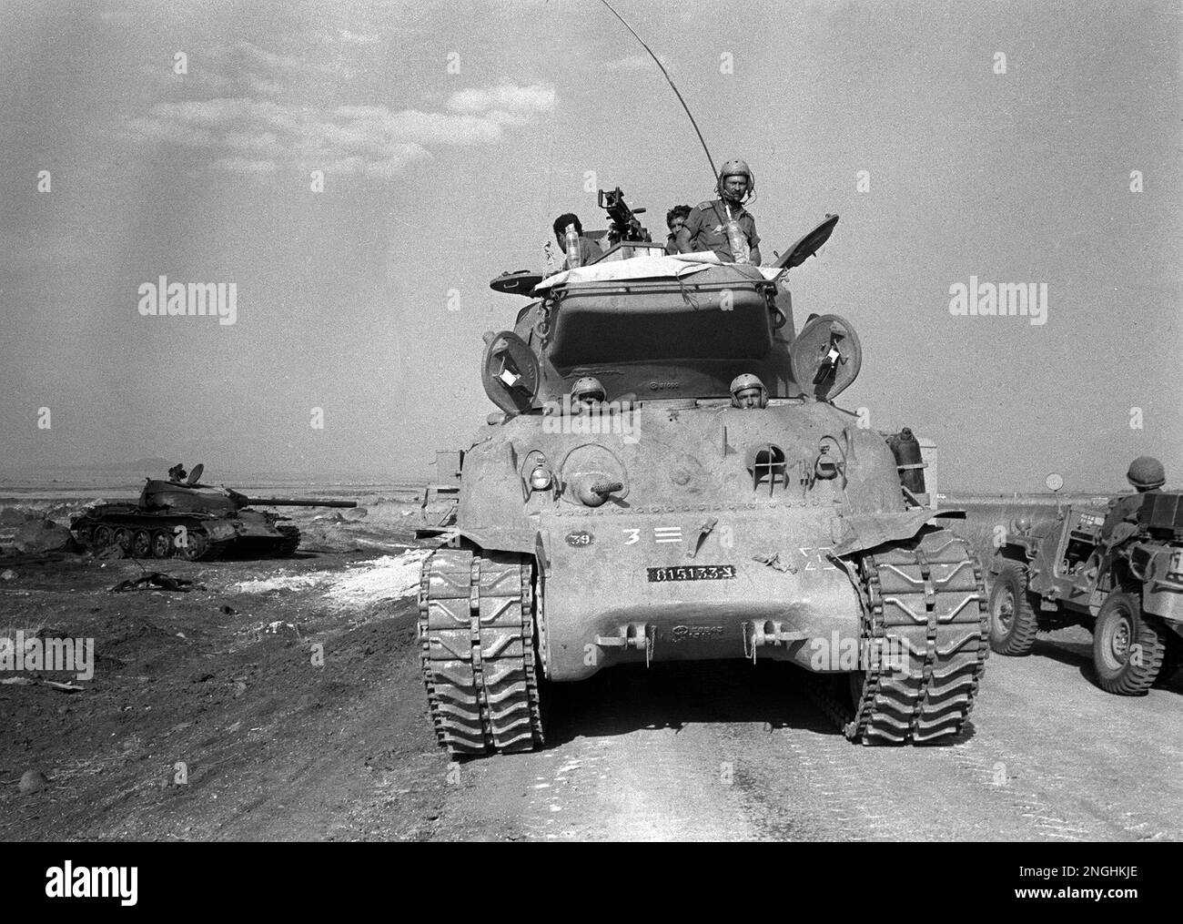 A Israeli tank passes the remains of a Syrian tank in the Golan Heights ...
