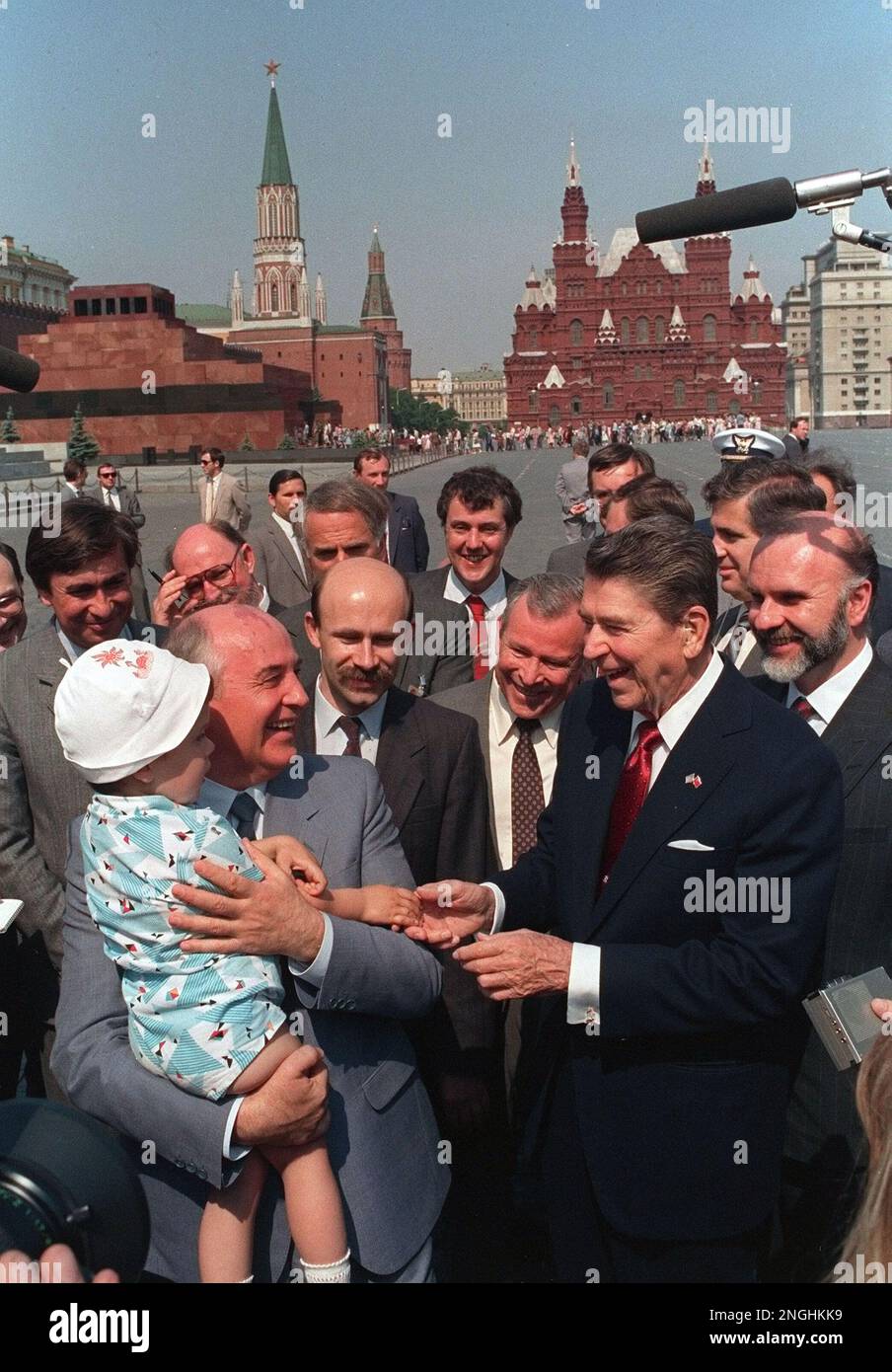 U.S. President Ronald Reagan shakes the hand of a baby held by Soviet ...