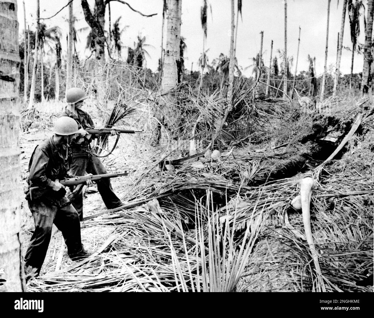Two American soldiers of the 32nd Division cautiously fire into a ...
