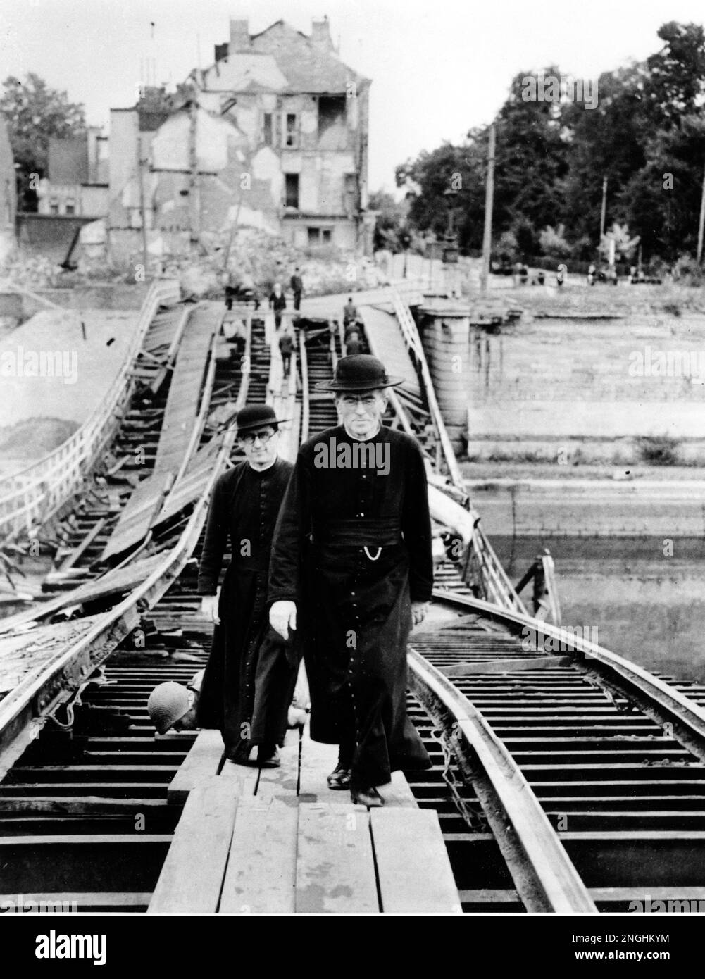 Two Belgian priests cross a ruined bridge as a U.S. Army engineer ...