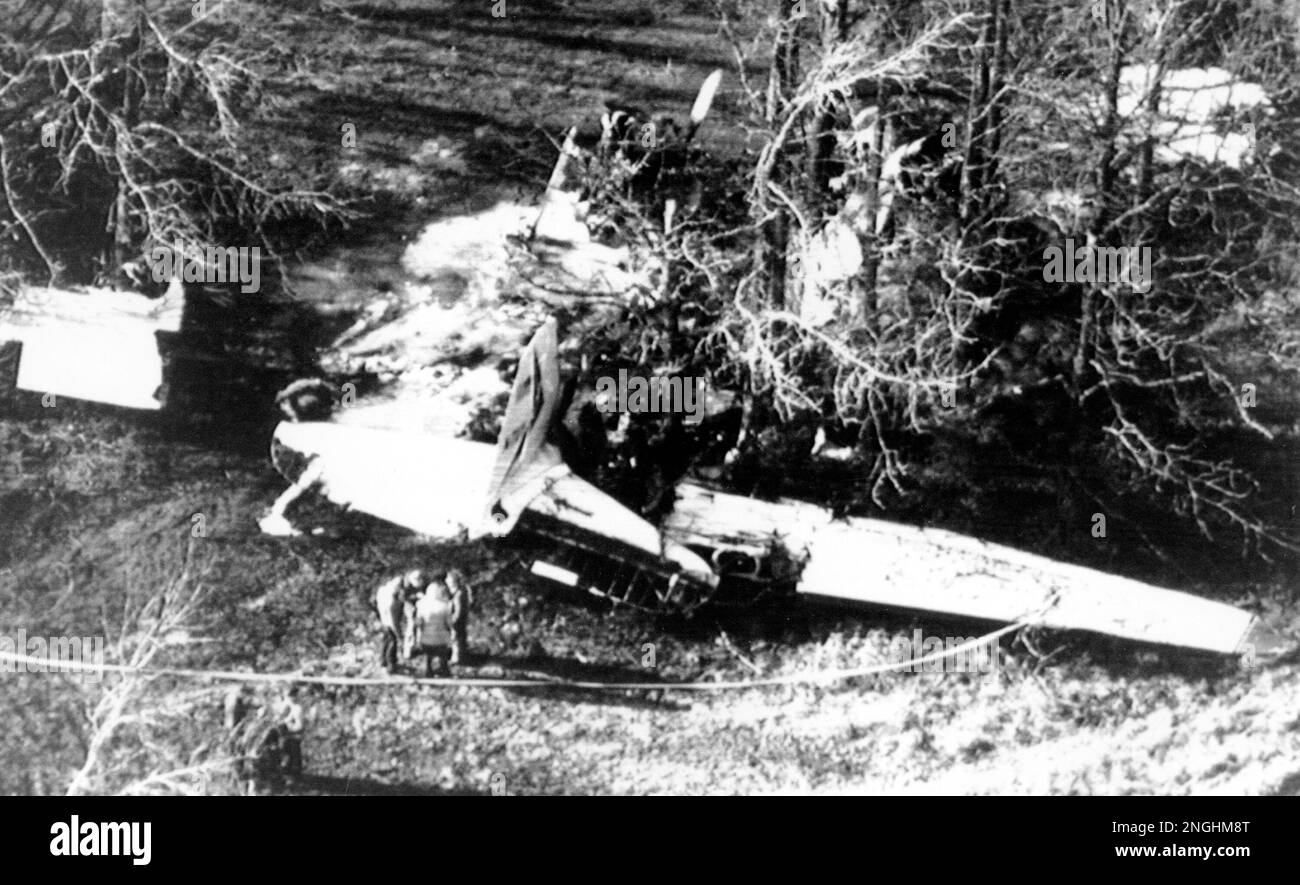 Firefighters and law officials stand near the wreckage of singer Ricky ...