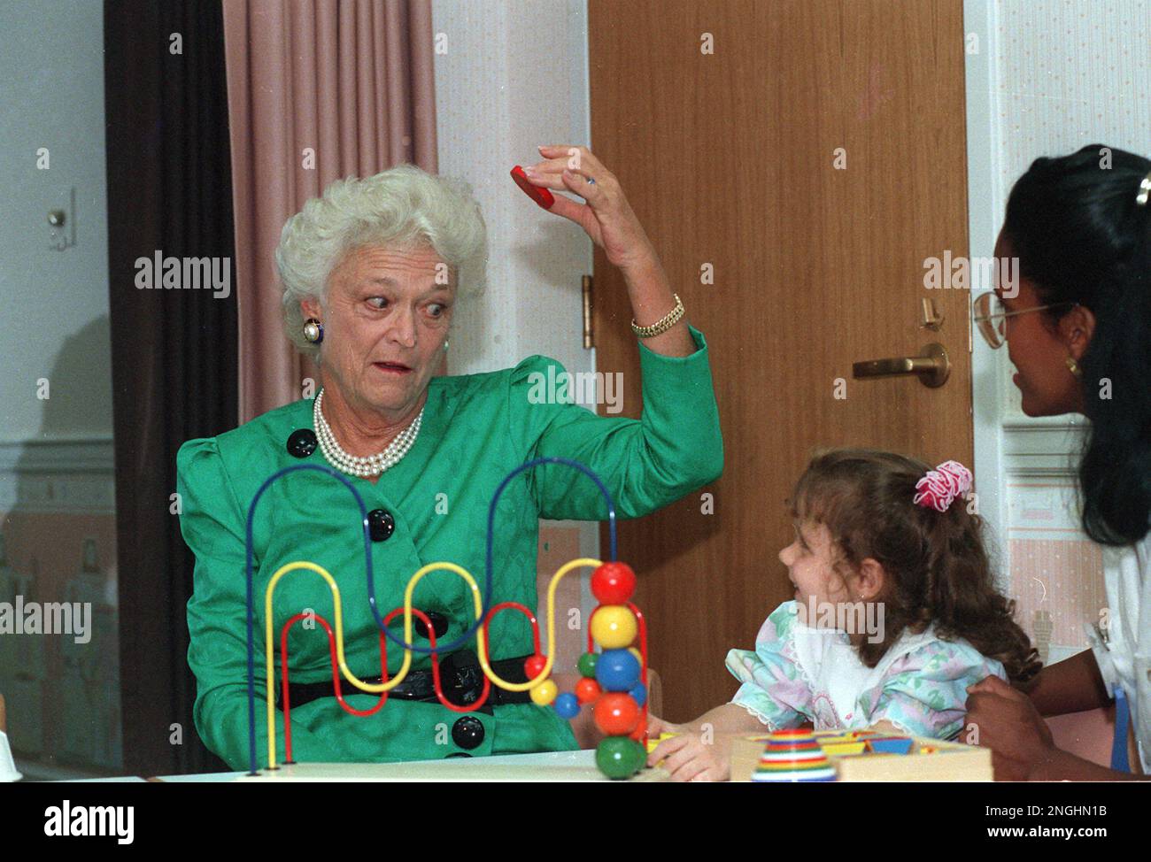 U.S. first lady Barbara Bush holds a domino as she visits with Nora ...