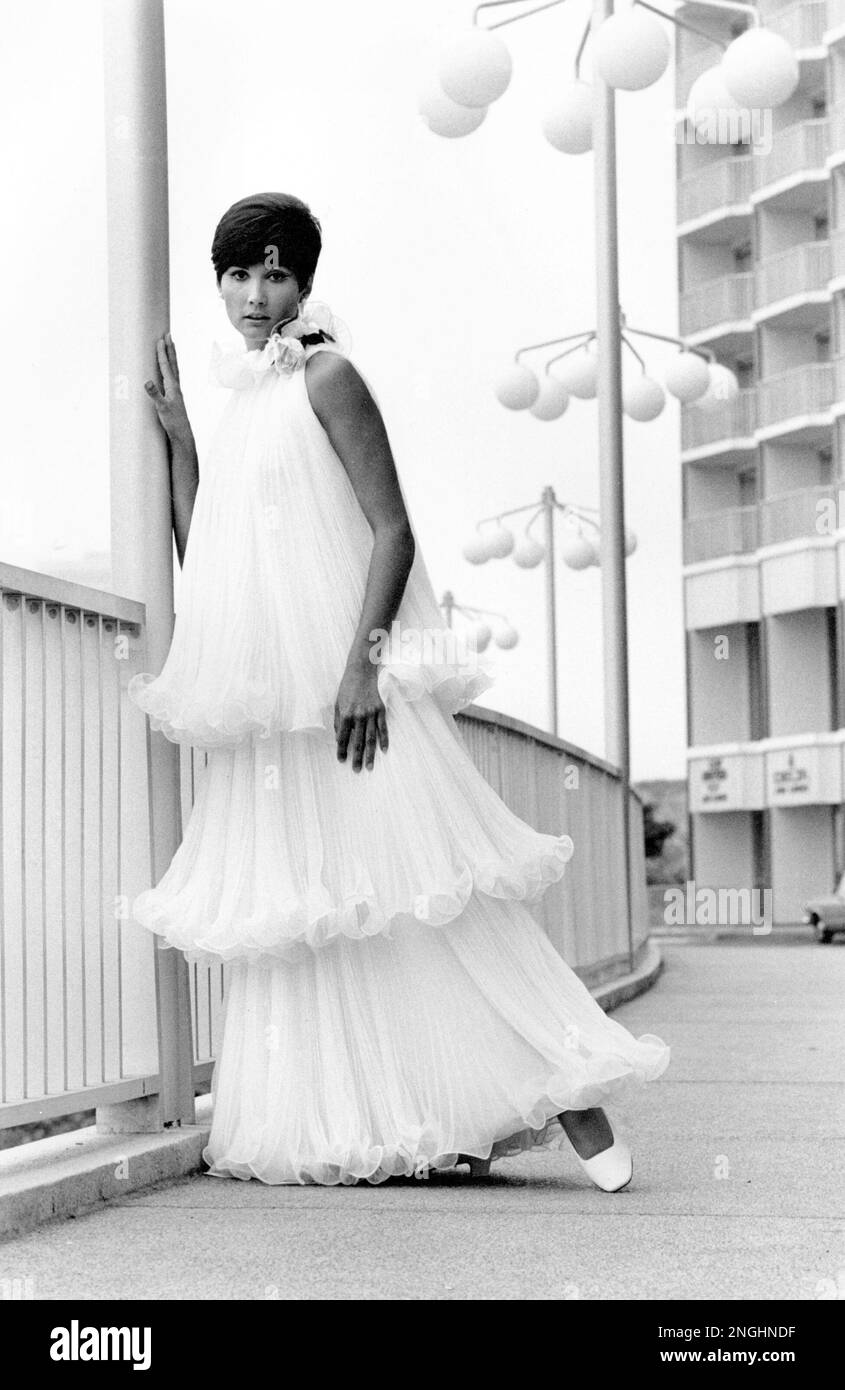 Gail Hire models a sleeveless white polyester gown featuring tiers of ...