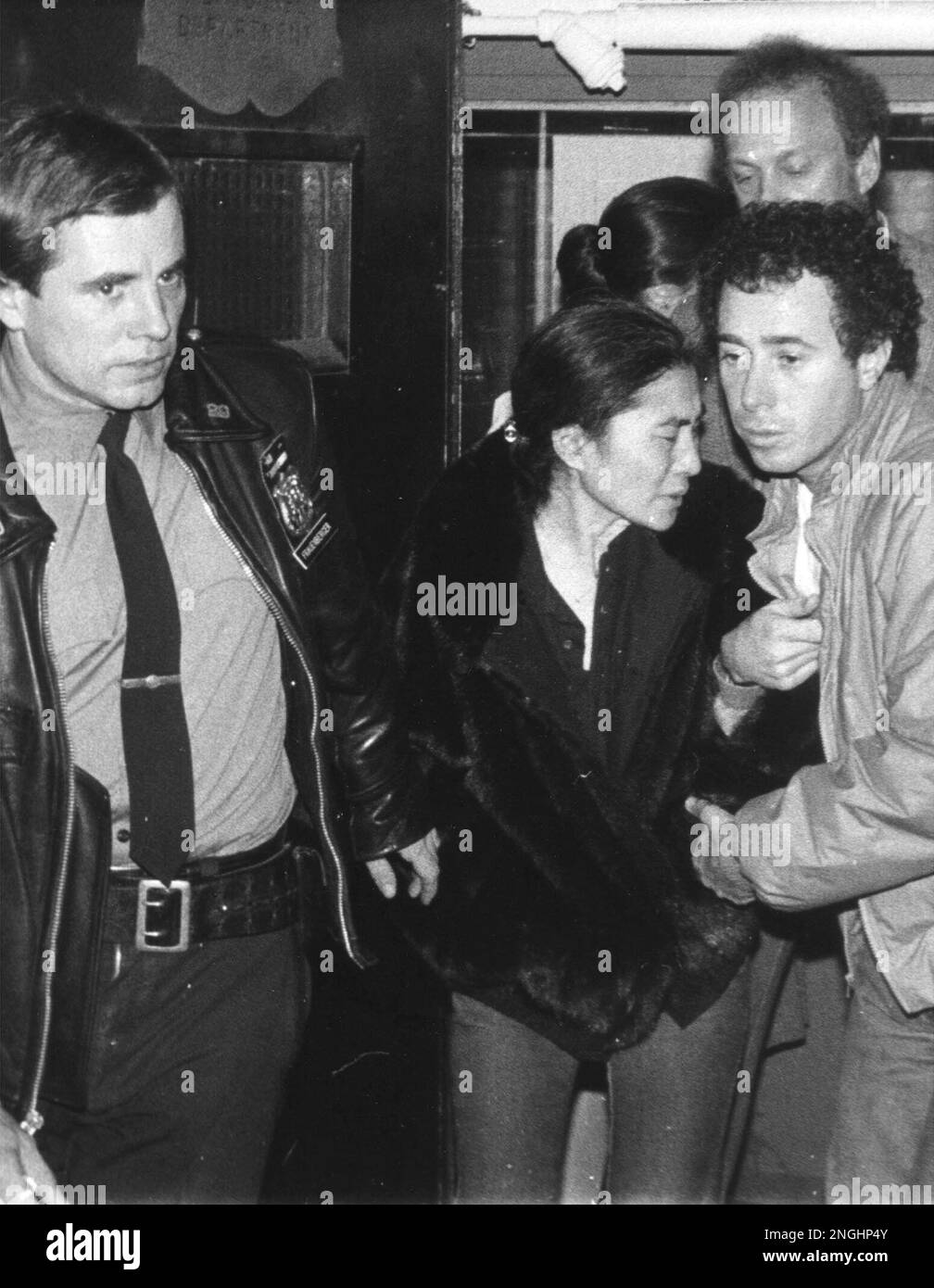Yoko Ono, center, is aided by a policeman and David Geffen, right, of ...