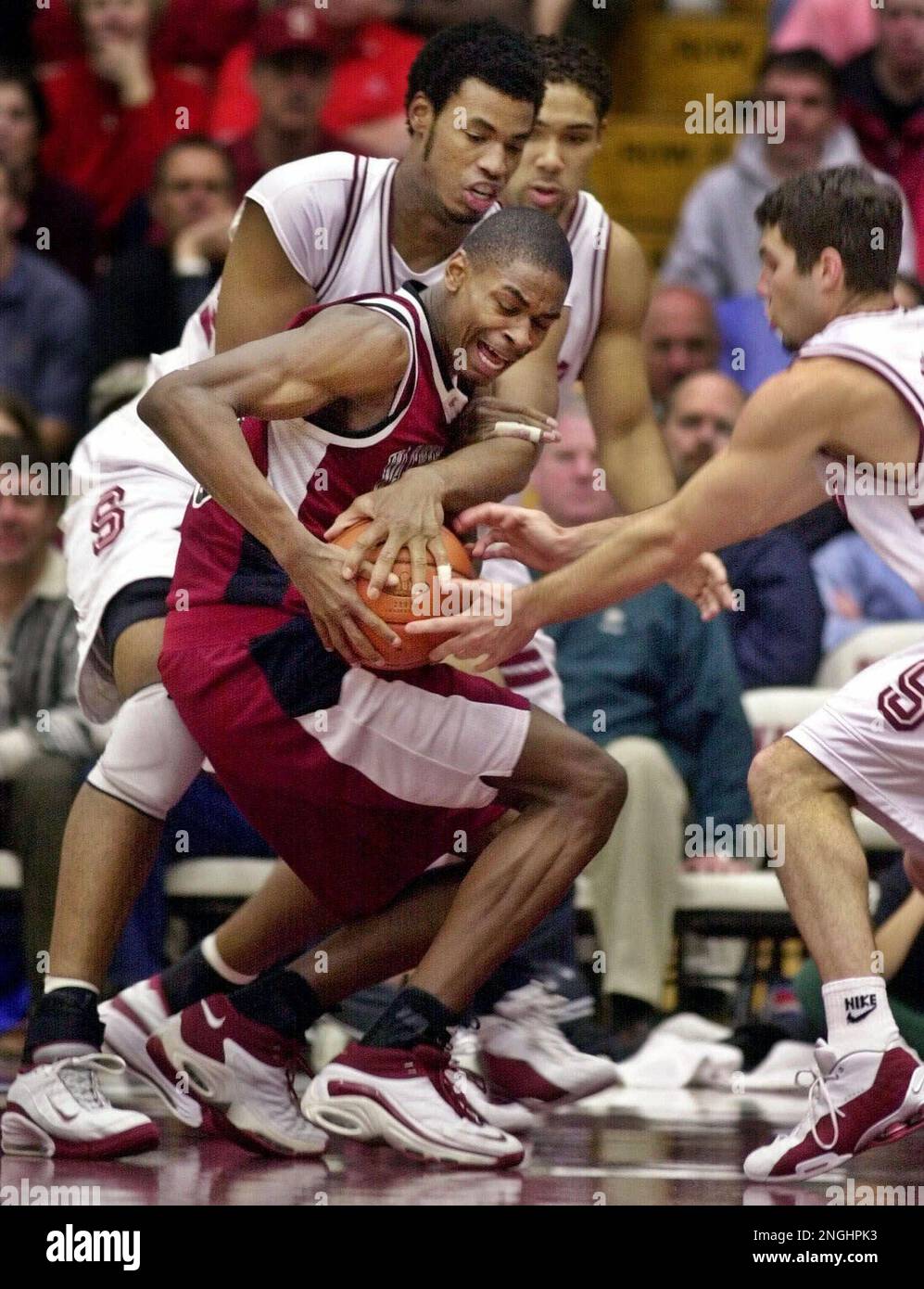 Washington State forward Milton Riley, center, is closely covered by ...