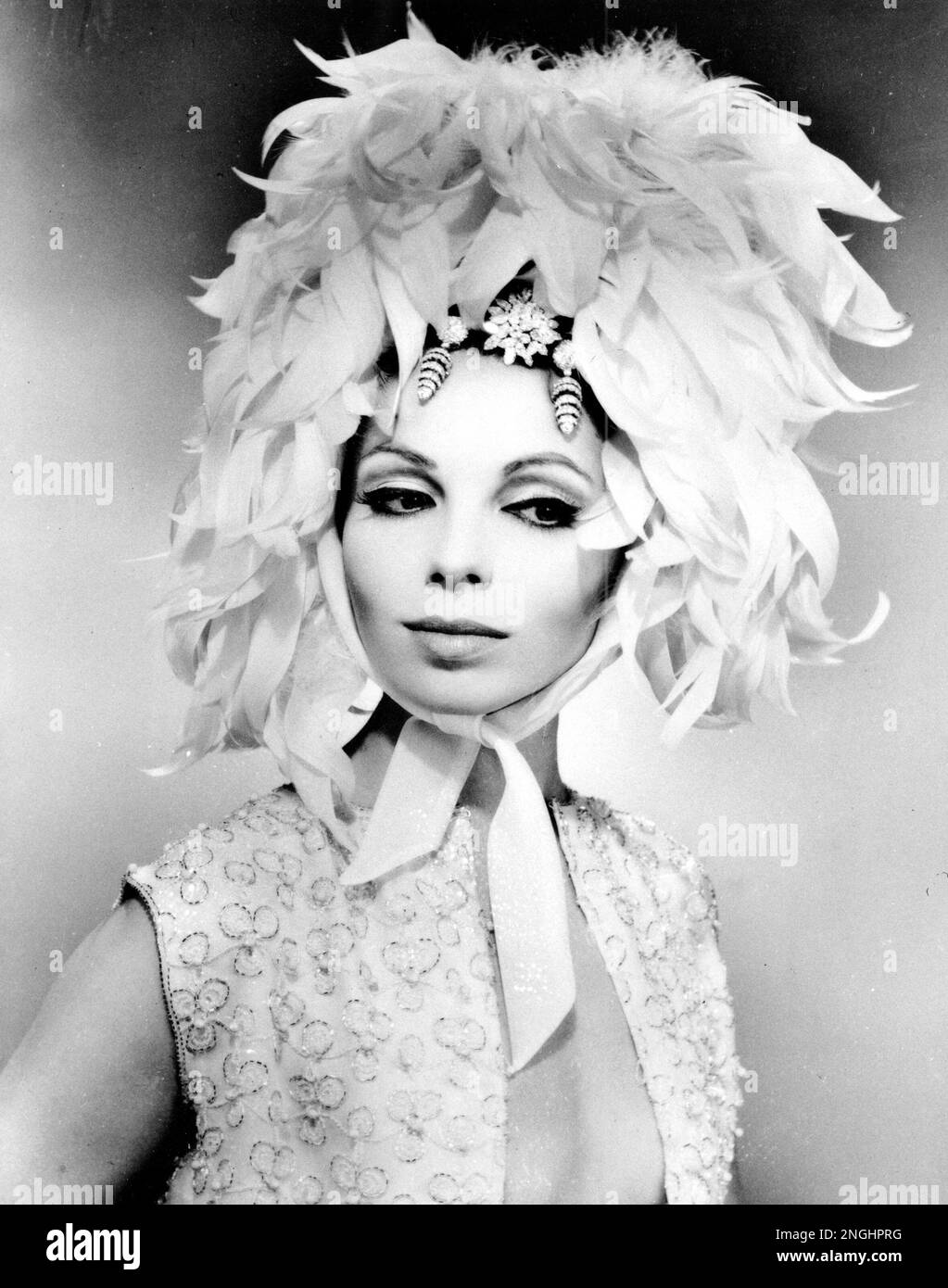 A bonnet covered in pink coq feathers and tied under the chin with ...