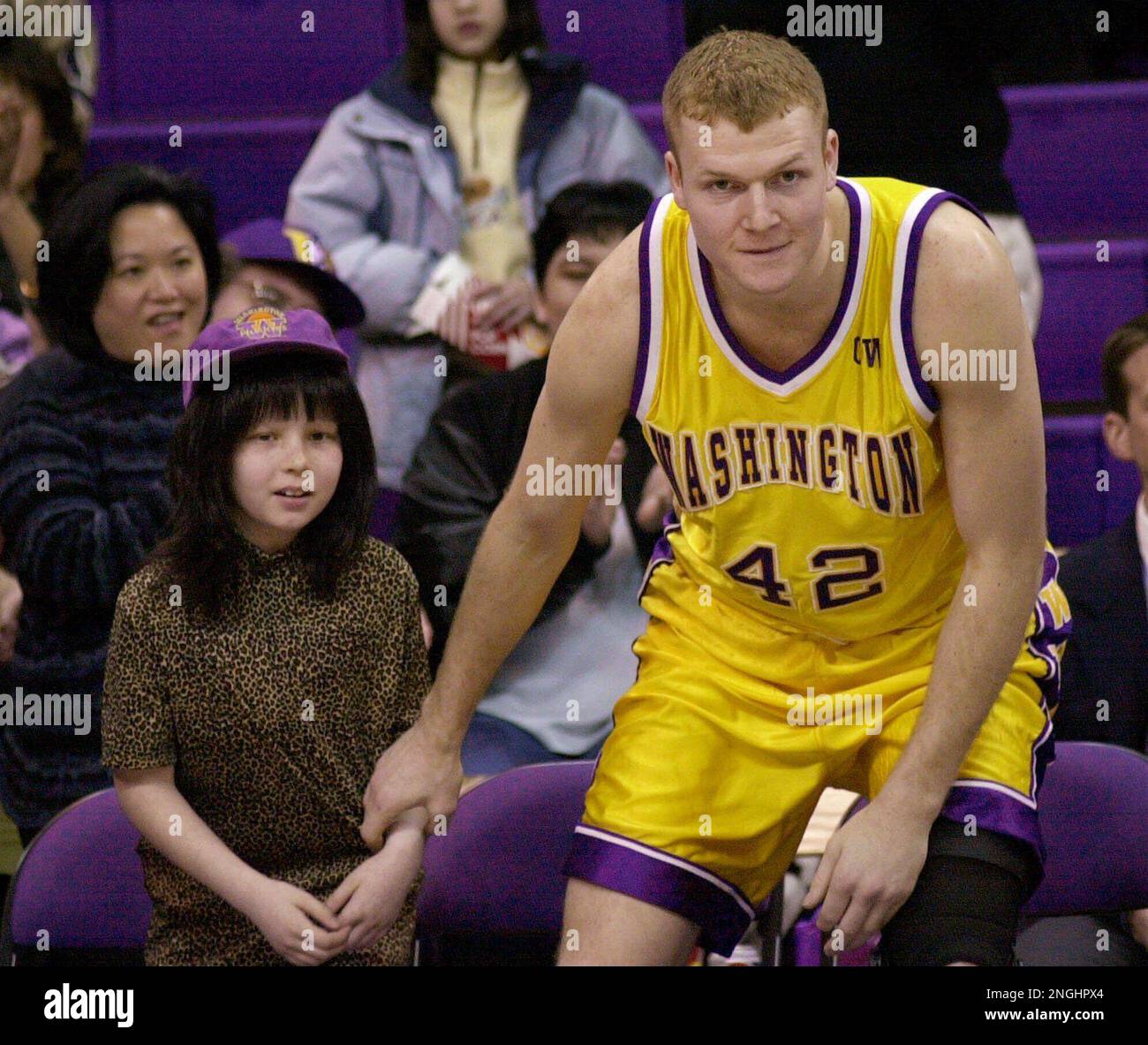Washington starting forward Thalo Green escorts Andrea Moore, 9, onto ...
