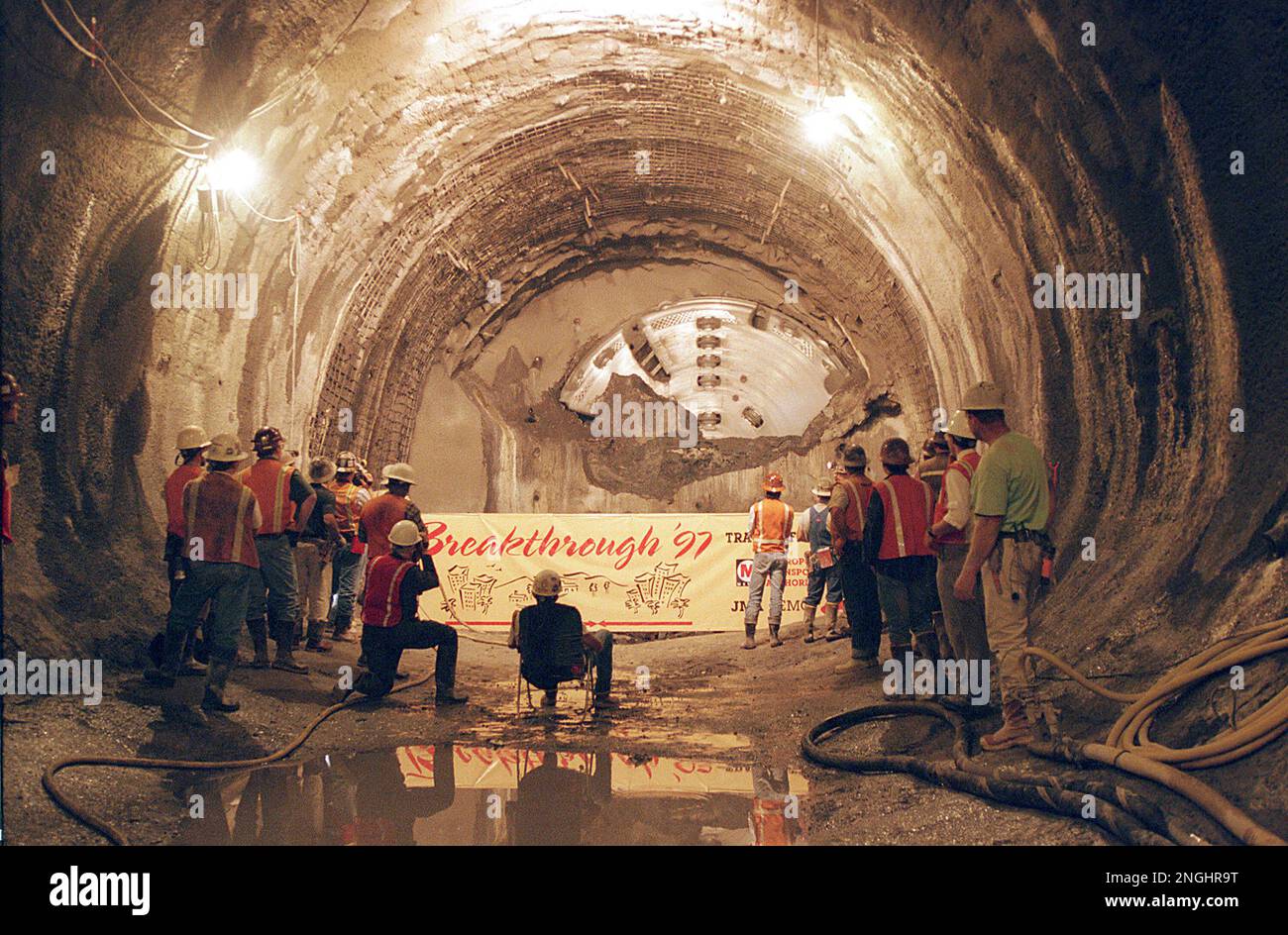 Subway tunnel workers watch as a giant tunnel boring machine carves ...